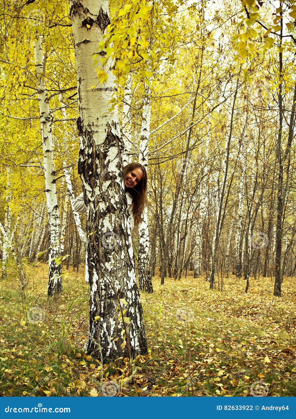 Cheerful Woman Looks Out from Behind a Tree Stock Photo - Image of ...