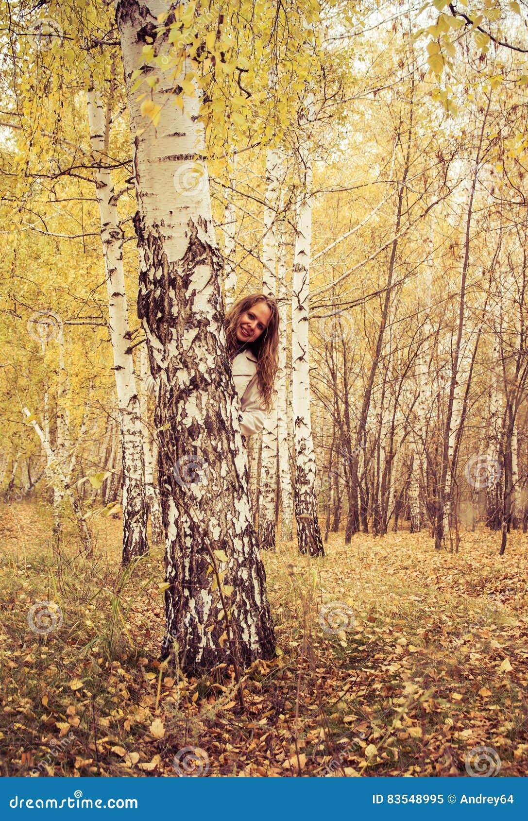 Cheerful Woman Looks Out from Behind a Tree Stock Image - Image of ...