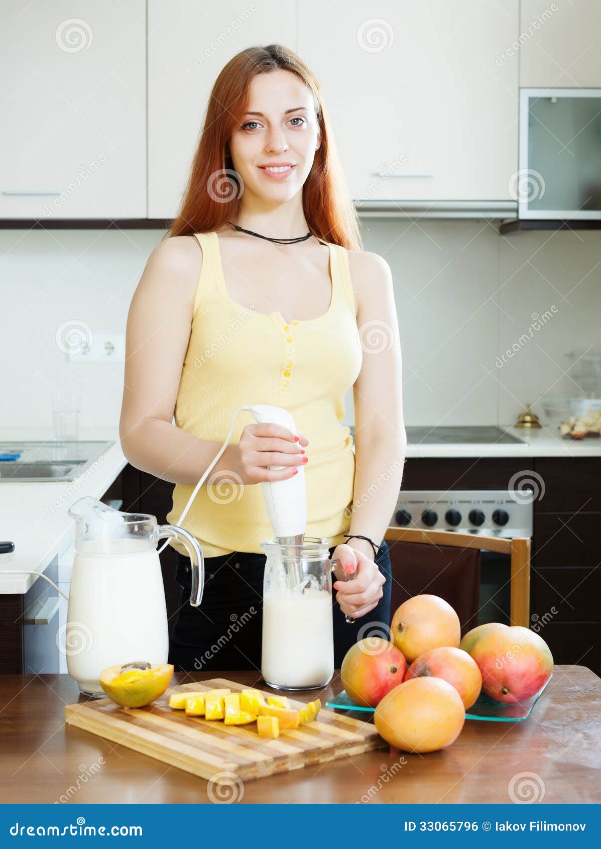 Cheerful Woman Making Milk Shake with Mango Stock Photo - Image of cook ...