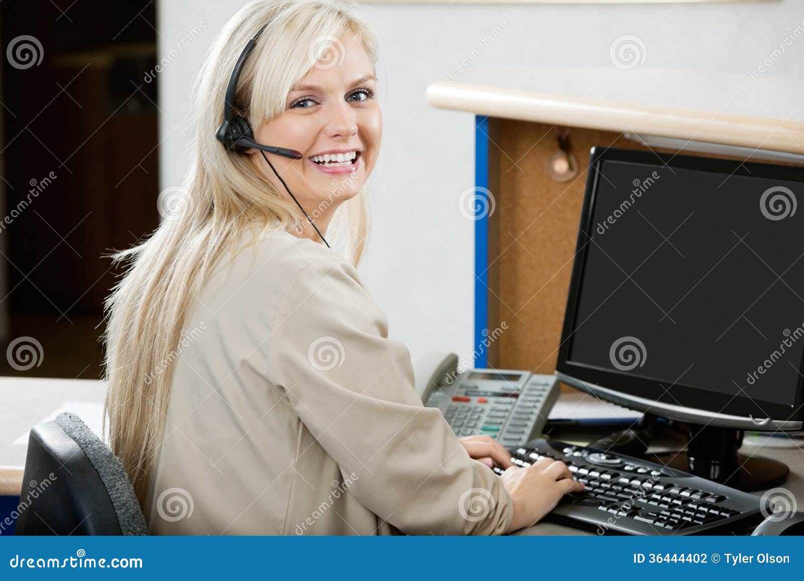 Cheerful Woman Using Computer at Reception Desk Stock Photo - Image of ...