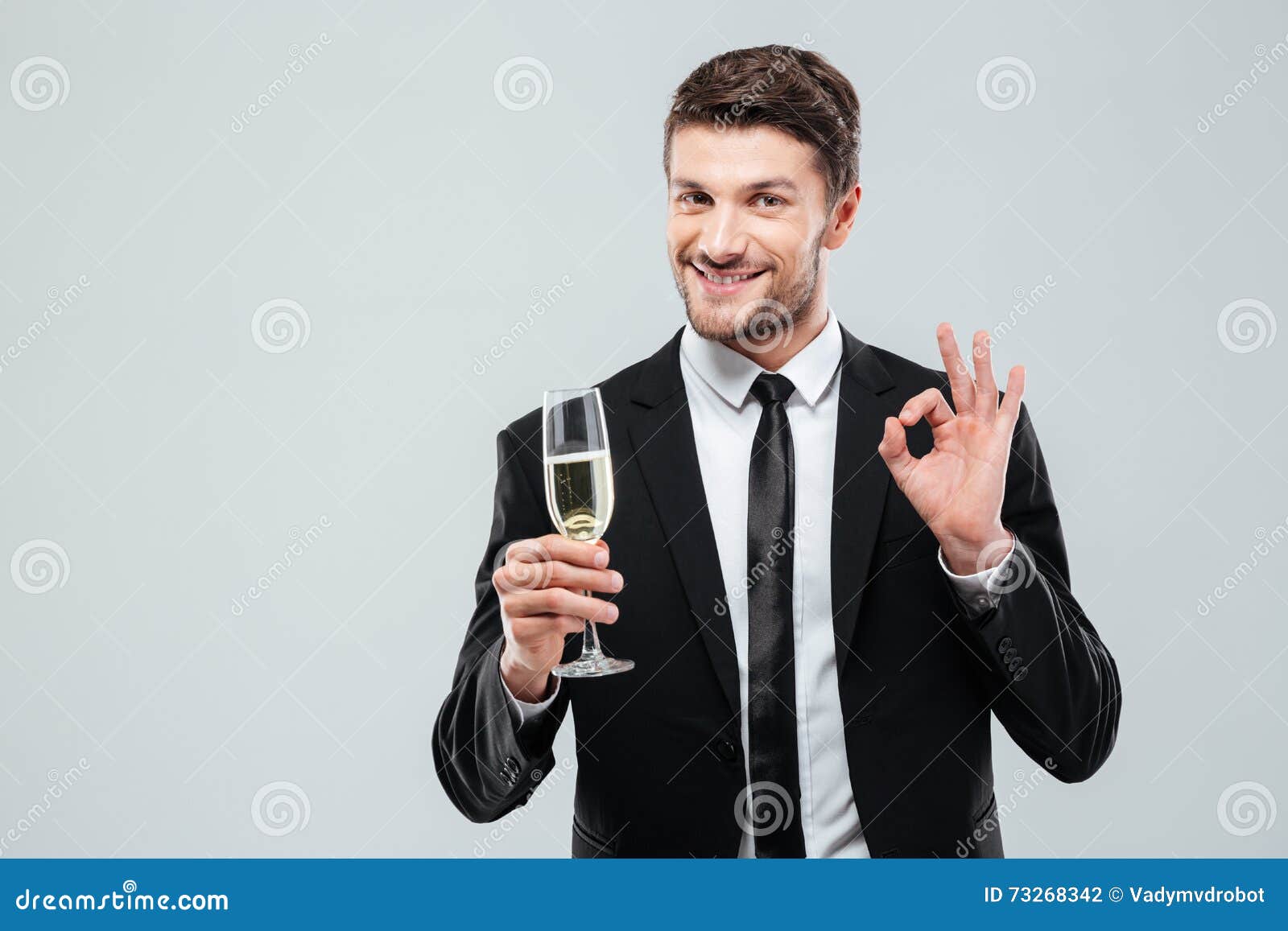 Cheerful Young Businessman Drinking Champagne And Showing Ok Sign Stock