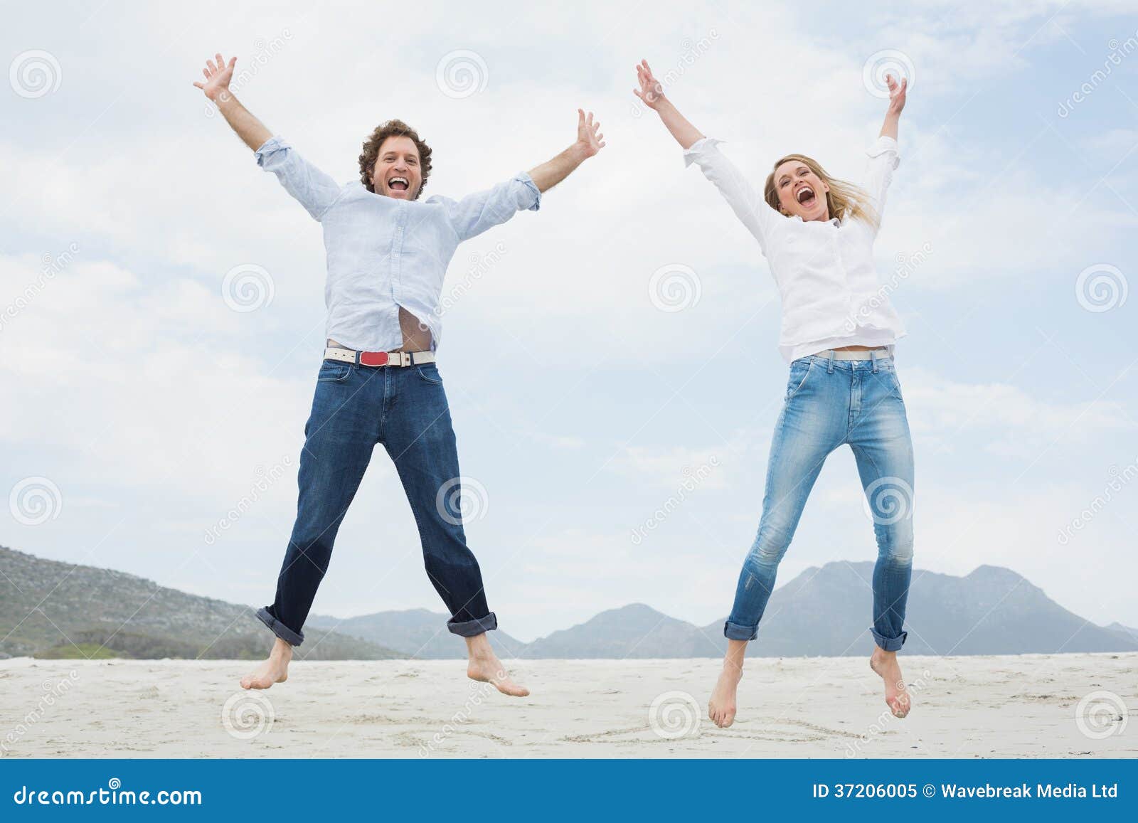 Cheerful Young Couple Jumping at Beach Stock Image - Image of caucasian ...
