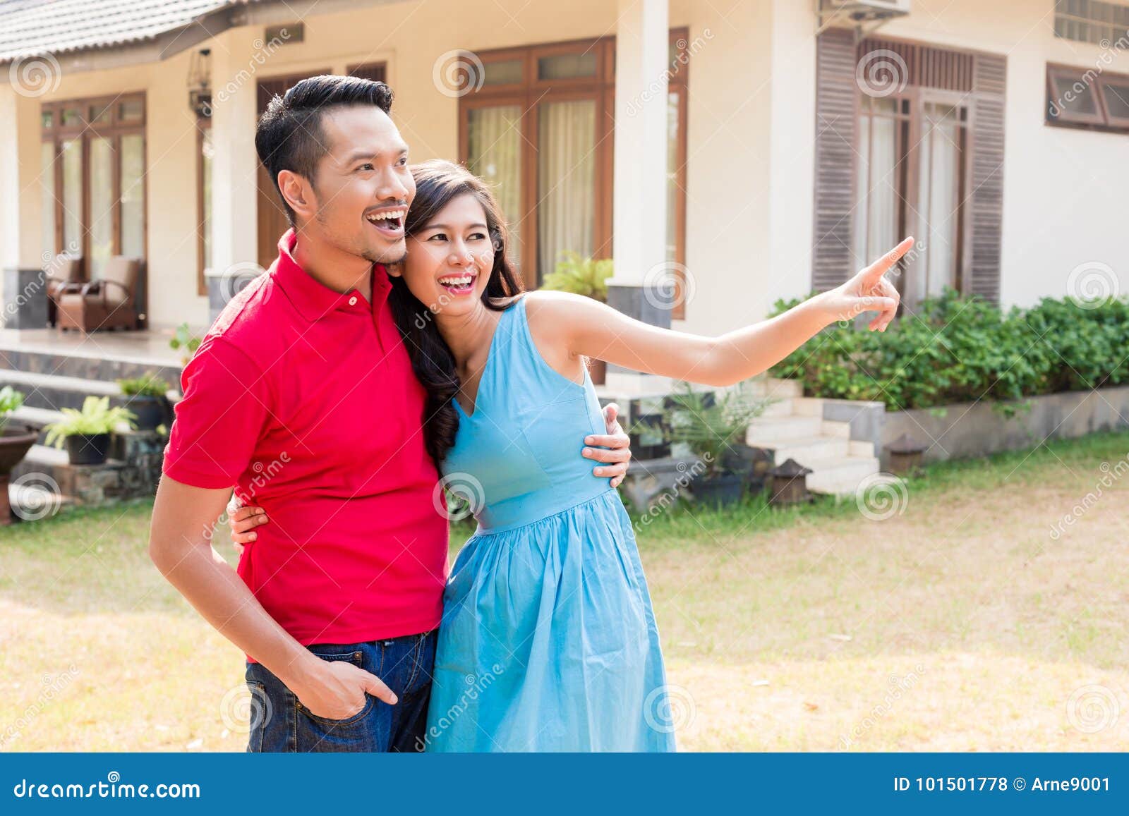 Cheerful Young Couple Looking in the Same Direction in Front of Stock ...