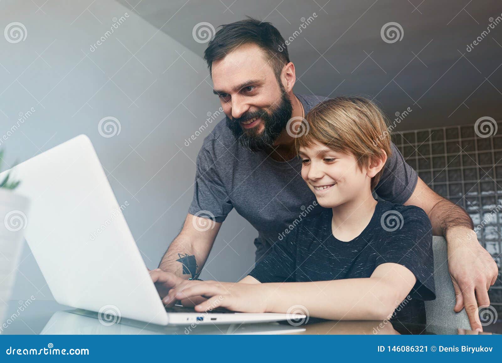 Cheerful Young Father with Cute Son Using Laptop Computer while Sitting ...