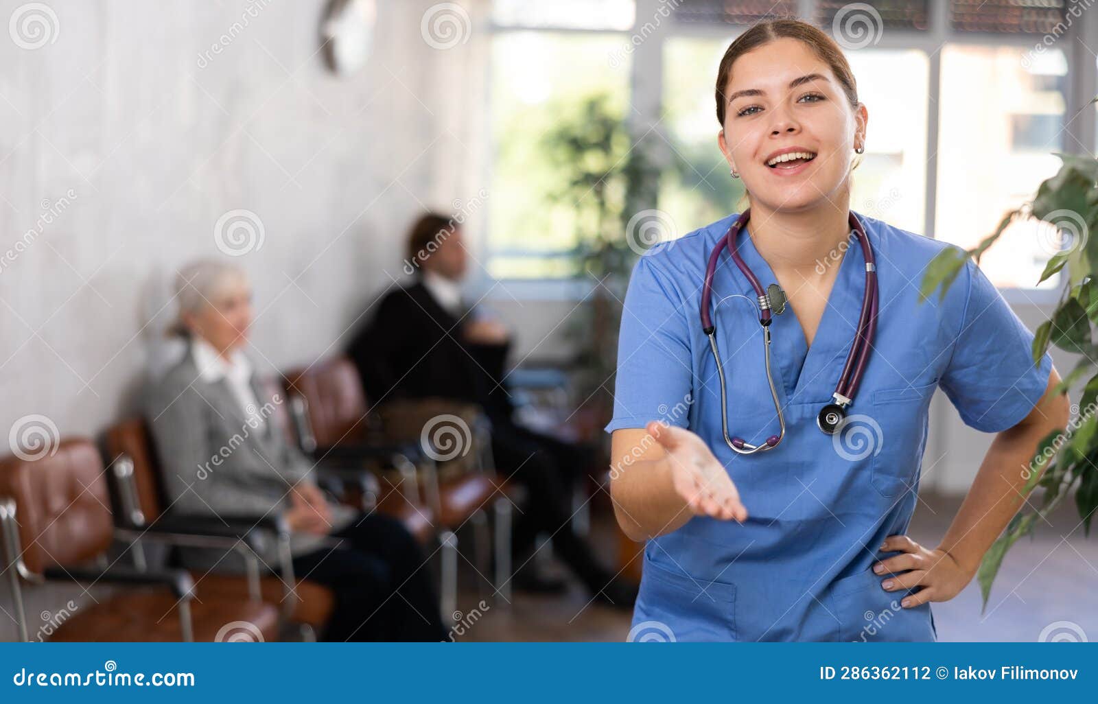 Cheerful Young Female Doctor Inviting Patients in Medical Office Stock ... Cheerful Young Female Doctor Inviting Patients in Medical Office Stock ...