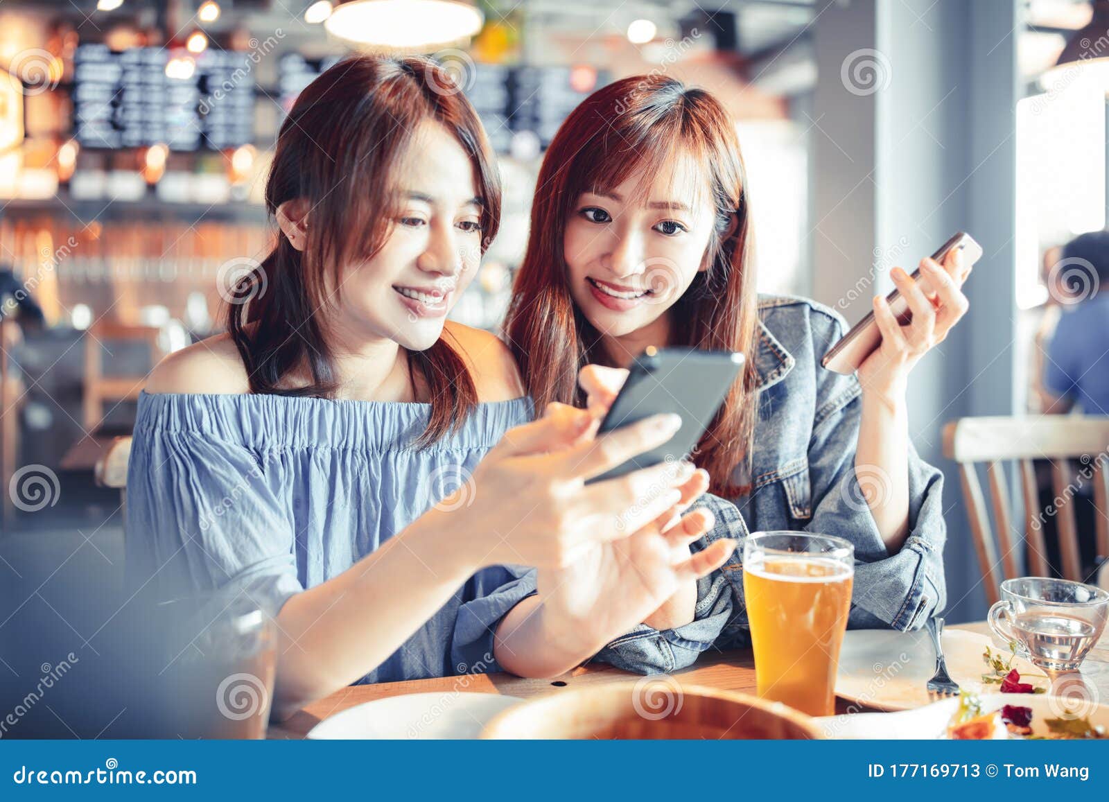 Cheerful Young Friends Looking at Smart Phone in Restaurant Stock Image ...
