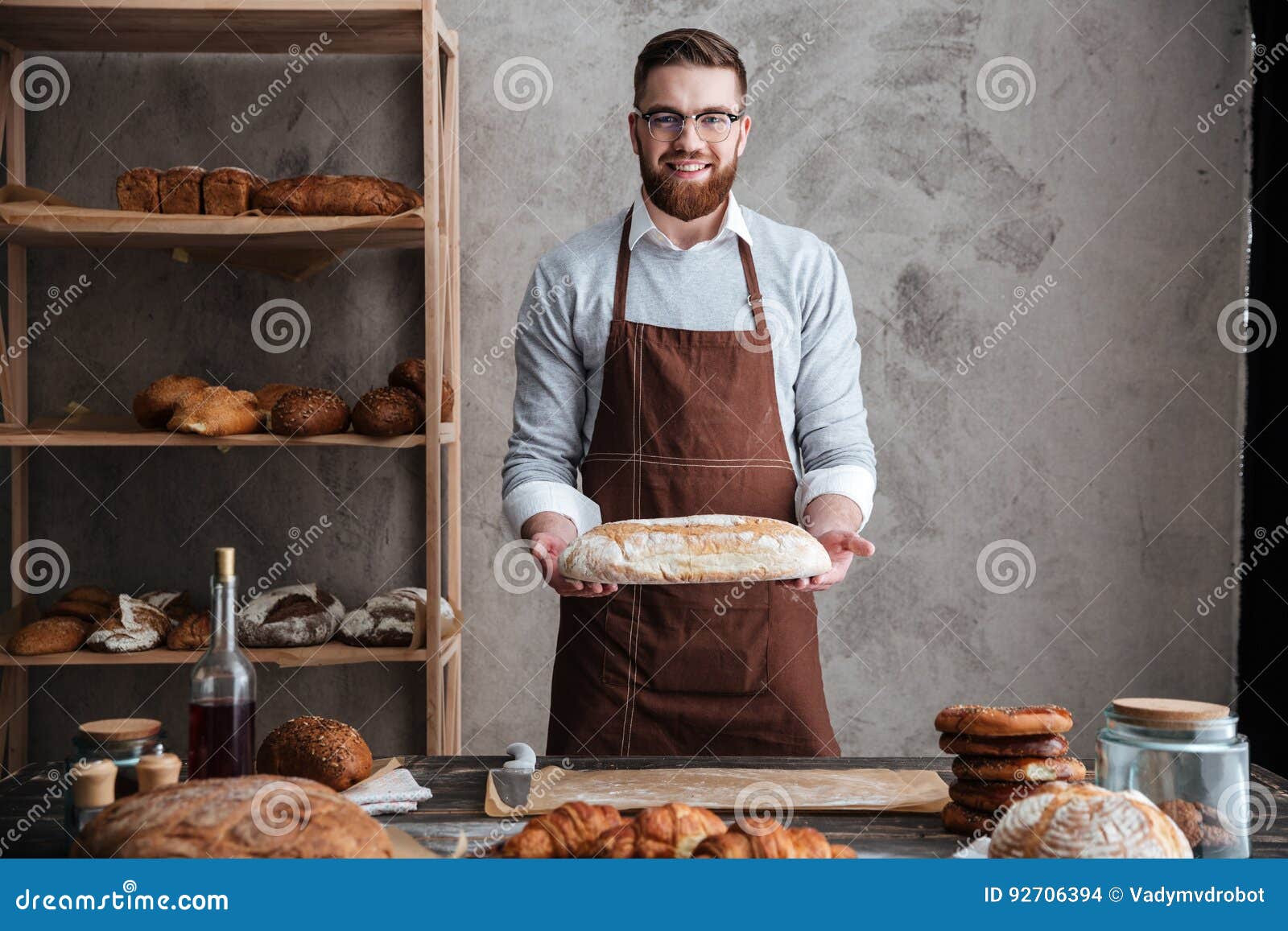Cheerful Young Man Baker Standing at Bakery Holding Bread Stock Photo ...