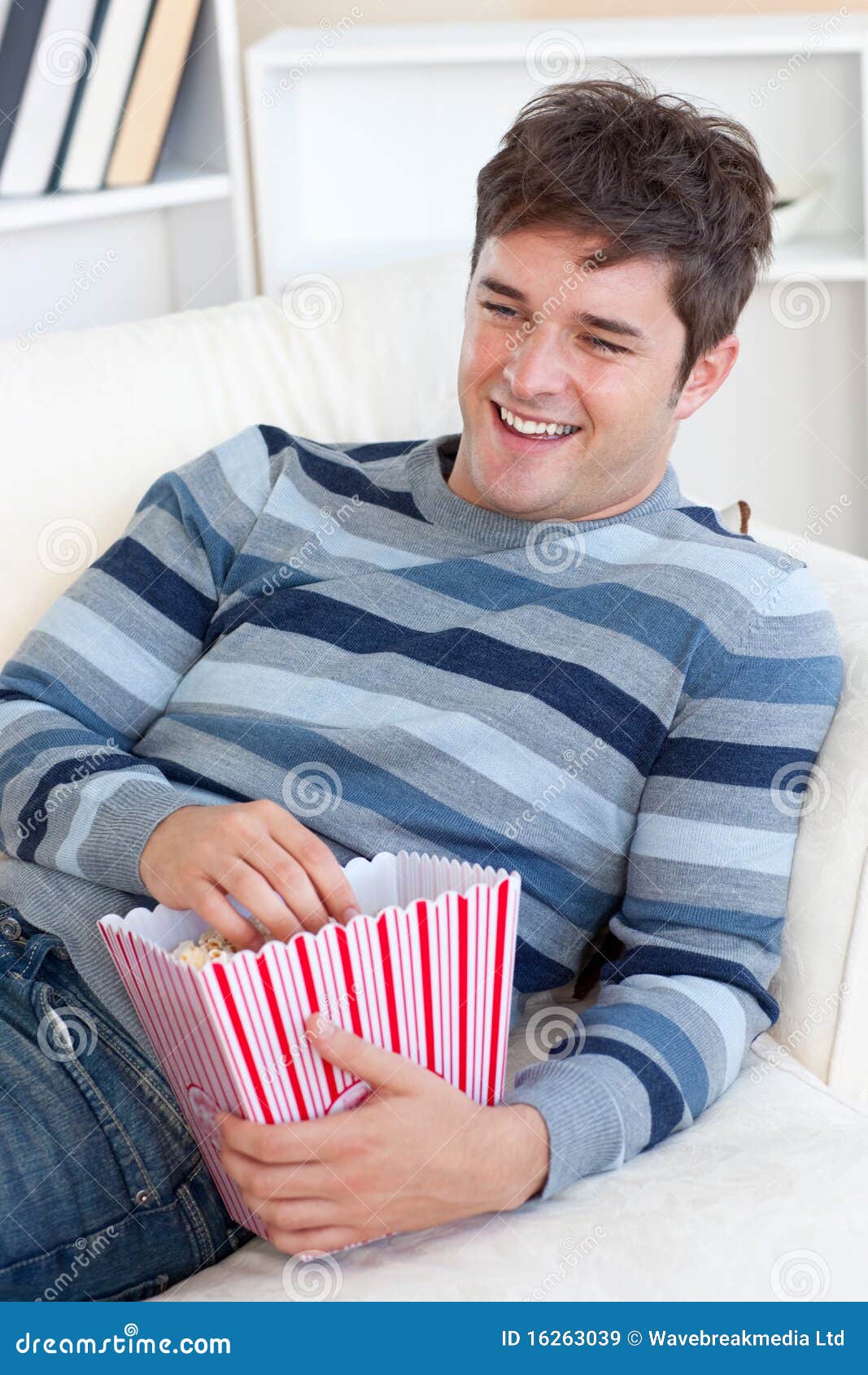 Cheerful Young Man Eating Popcorn on the Sofa Stock Image - Image of ...
