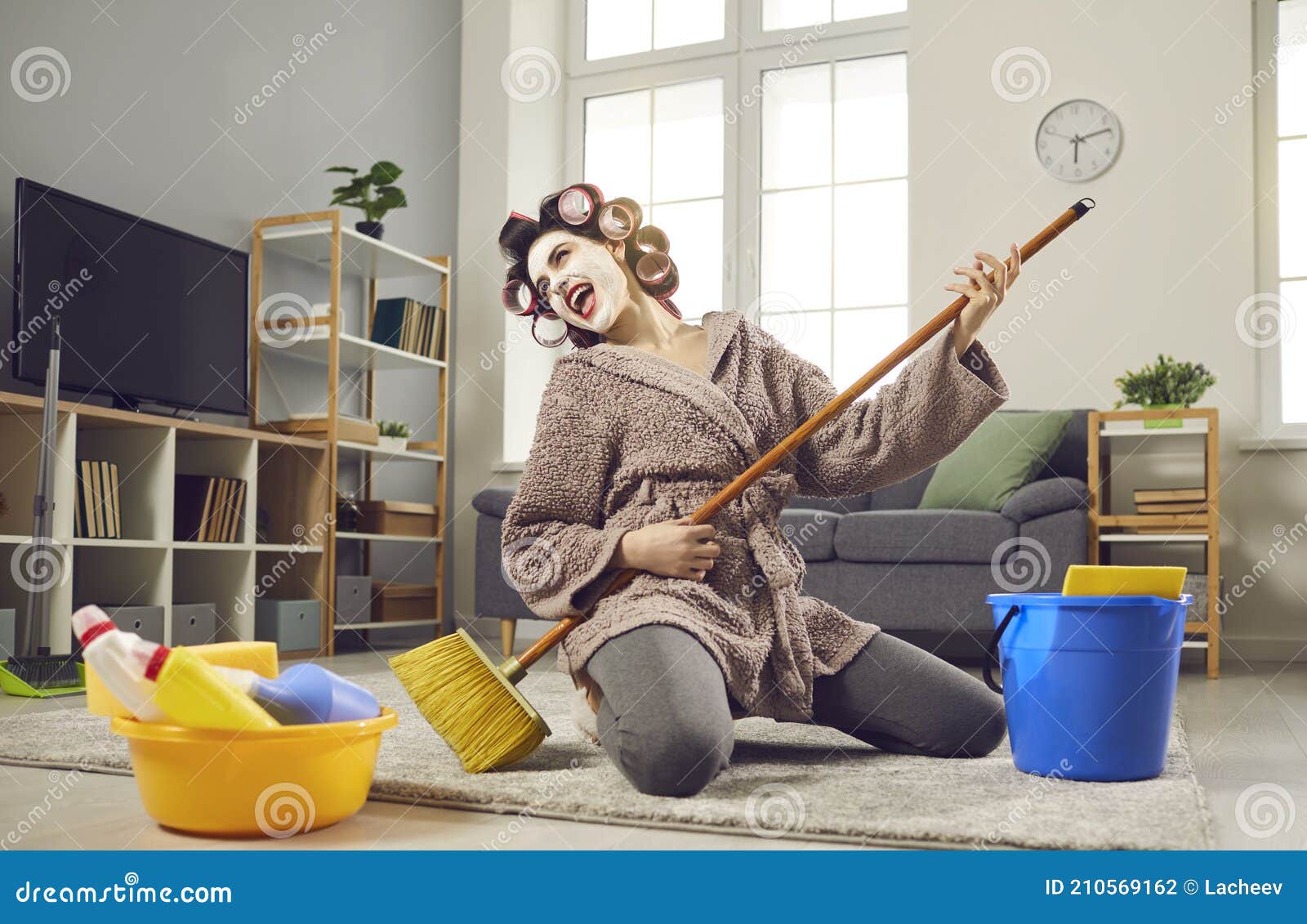 Happy Housewife Having Fun Playing On Mop Guitar And Singing While