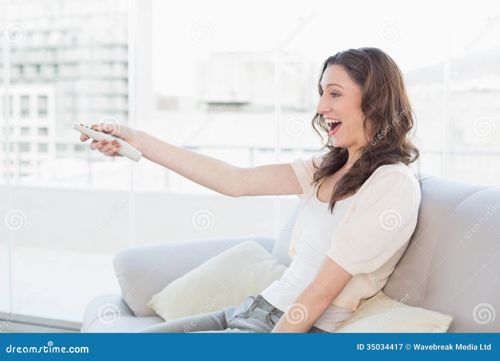 Cheerful Young Woman with Remote Control Sitting on Sofa Stock Image ...