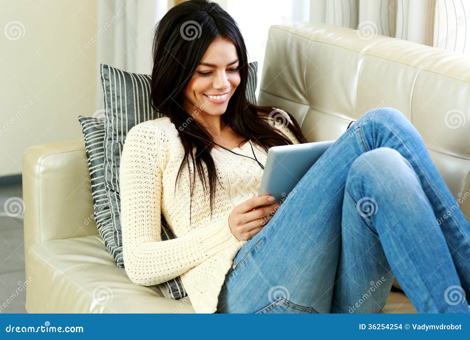 Cheerful Young Woman Resting on a Sofa with Tablet Computer Stock Photo ...