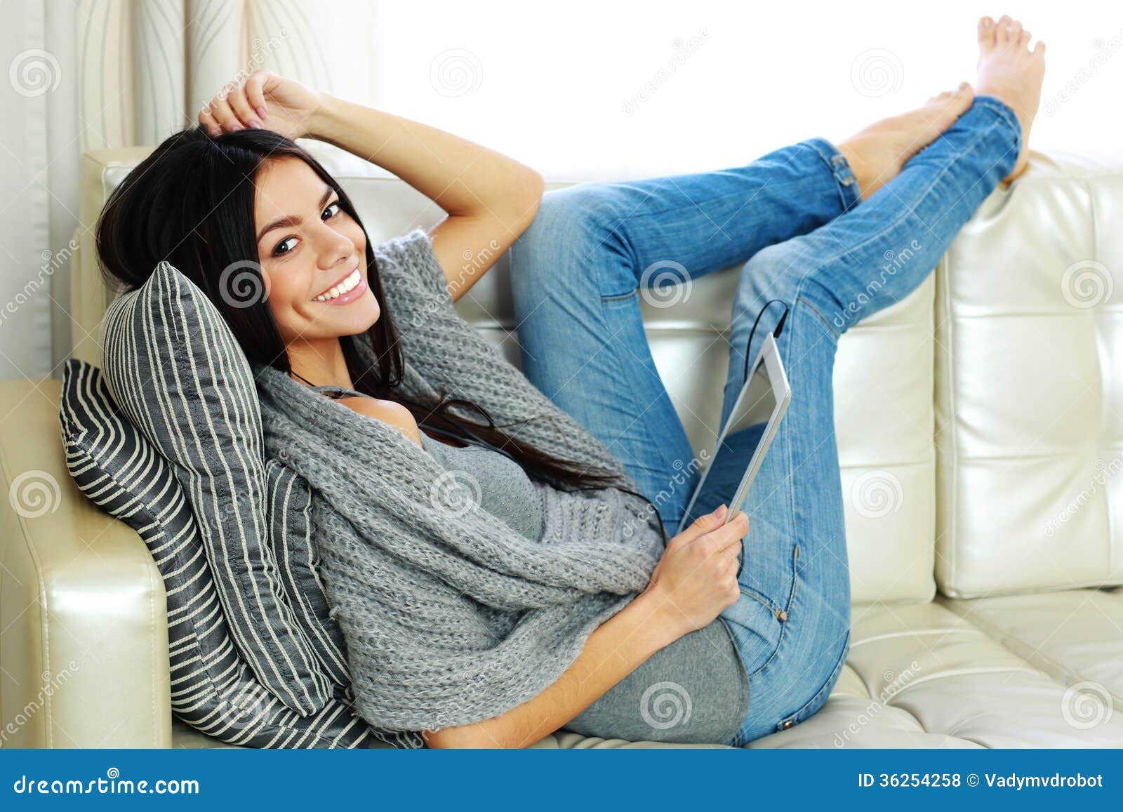 Cheerful Young Woman Resting on a Sofa with Tablet Computer Stock Photo ...