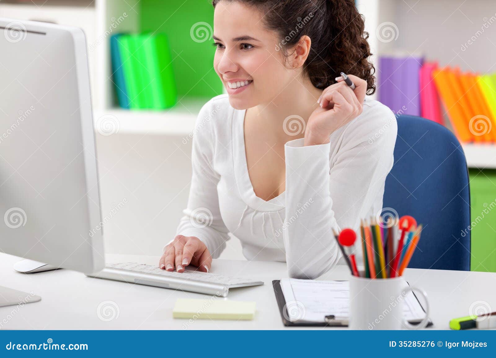 Cheerful Young Woman Using Computer Stock Photo - Image of book ...