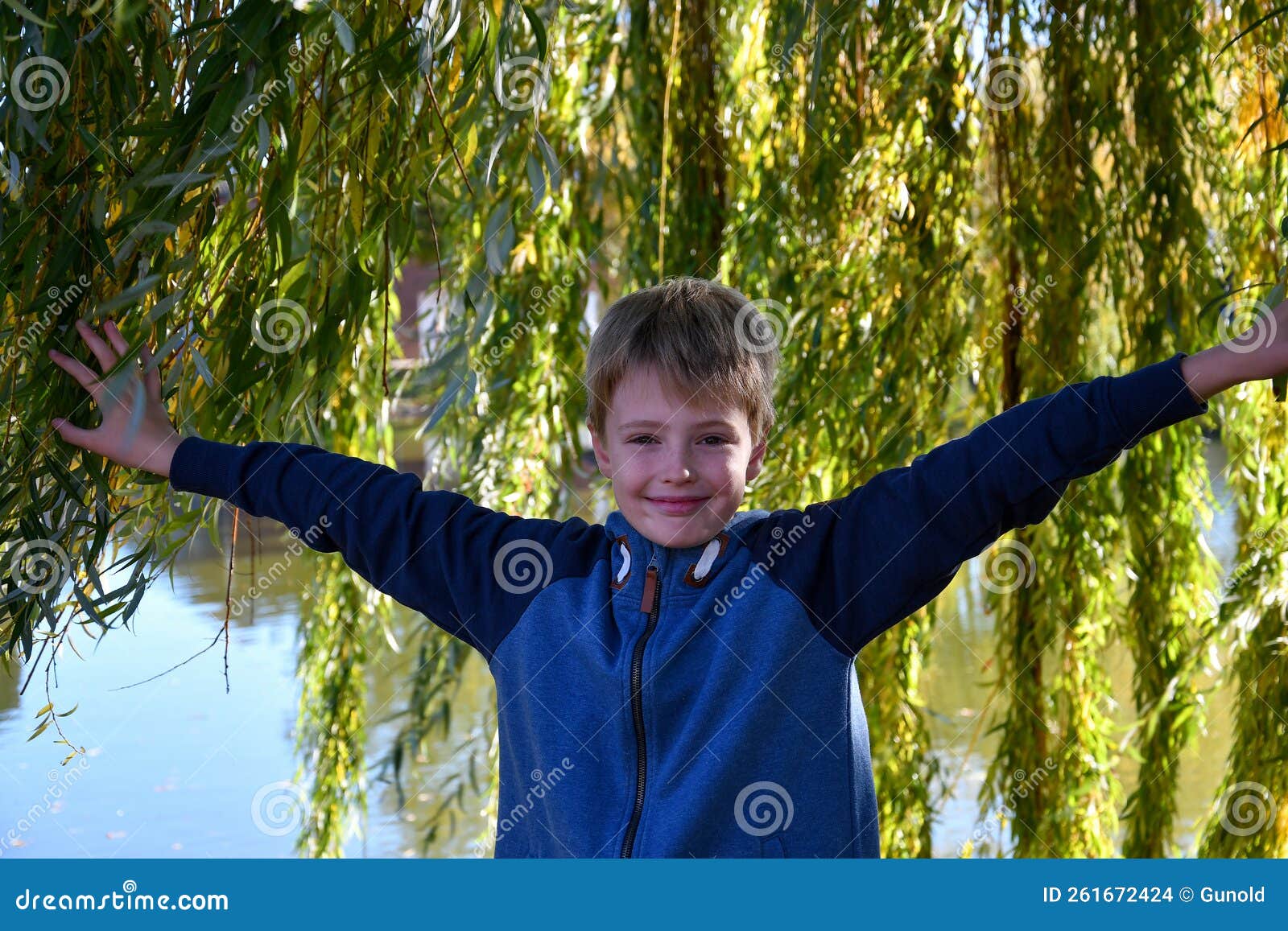 Cheering Boy in Front of a Weeping Willow Tree Stock Photo - Image of ...