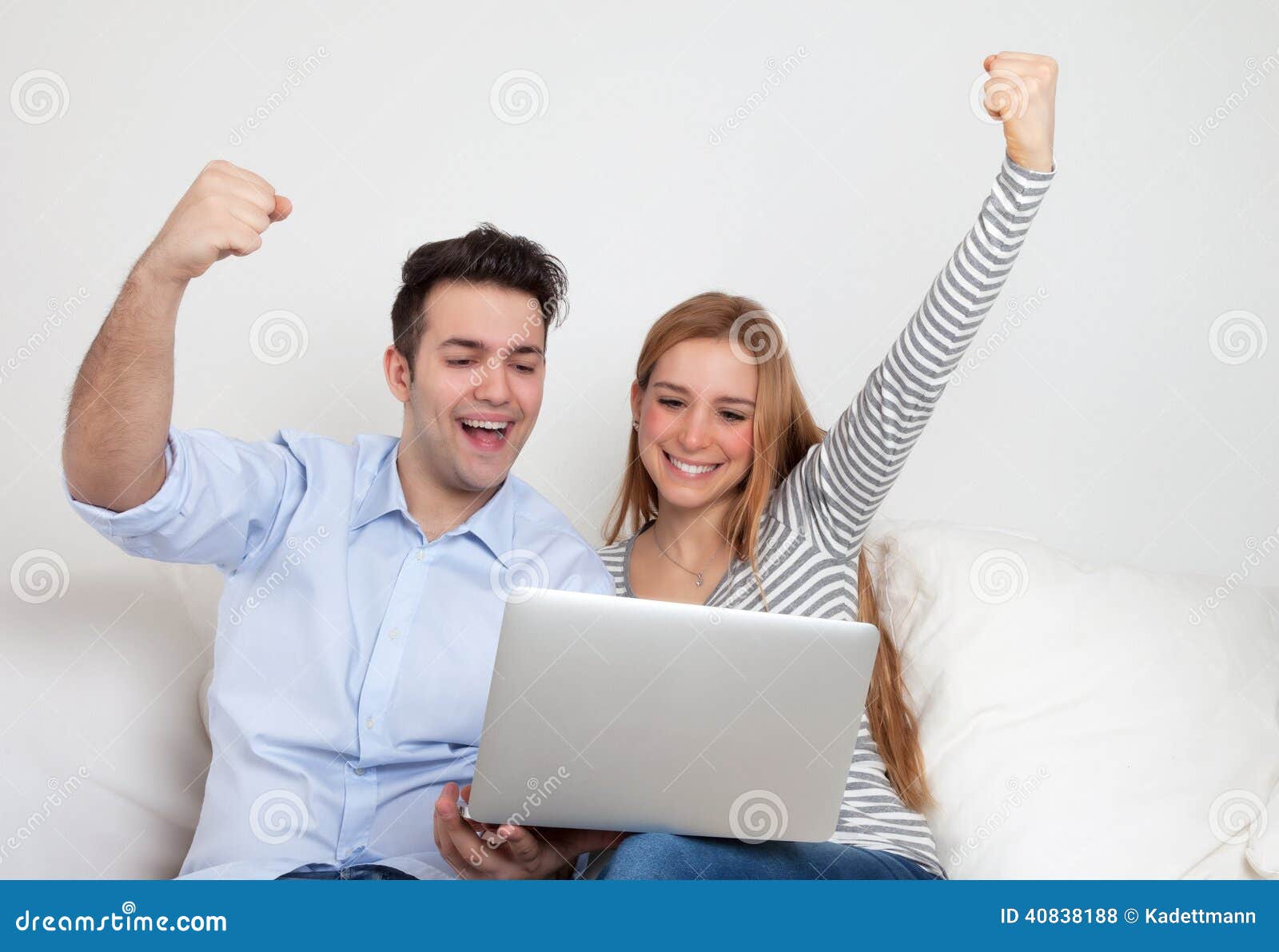 Cheering Young Couple on a Sofa with Notebook Stock Photo - Image of ...