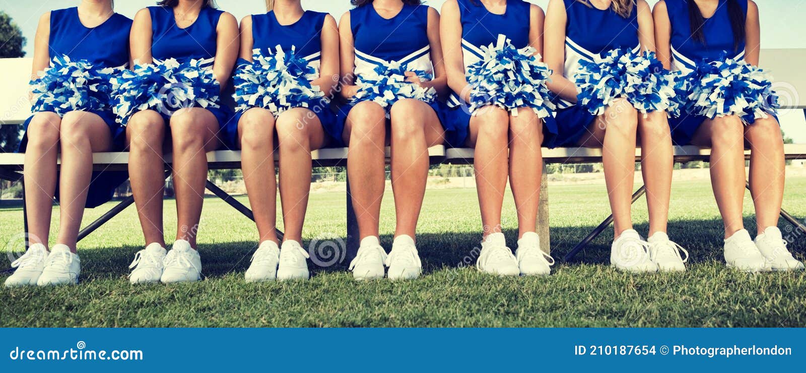 Cheerleading Squad Sitting on Bench Stock Photo - Image of grass ...
