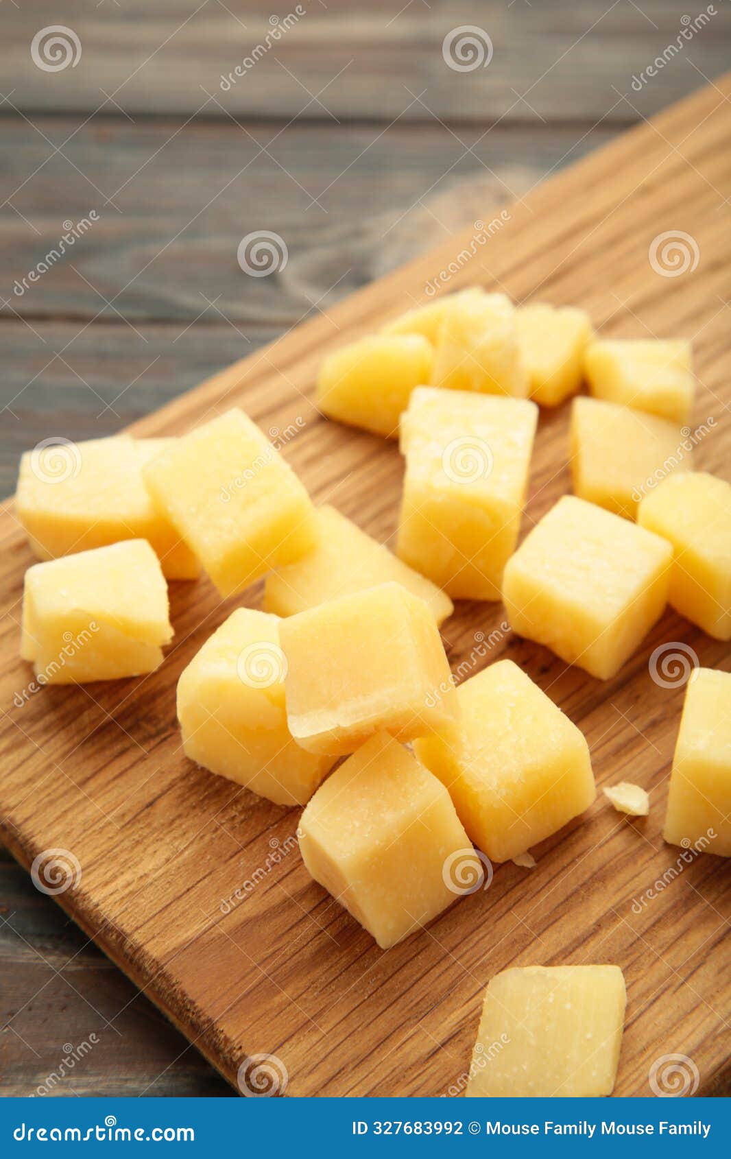 Cheese Cubes on Cutting Board on Brown Background. Parmesan Stock Photo ...