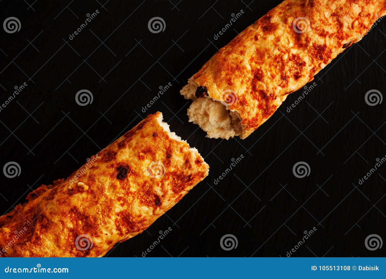 Cheese Roll Split into Two Parts on a Black Background Stock Photo ...