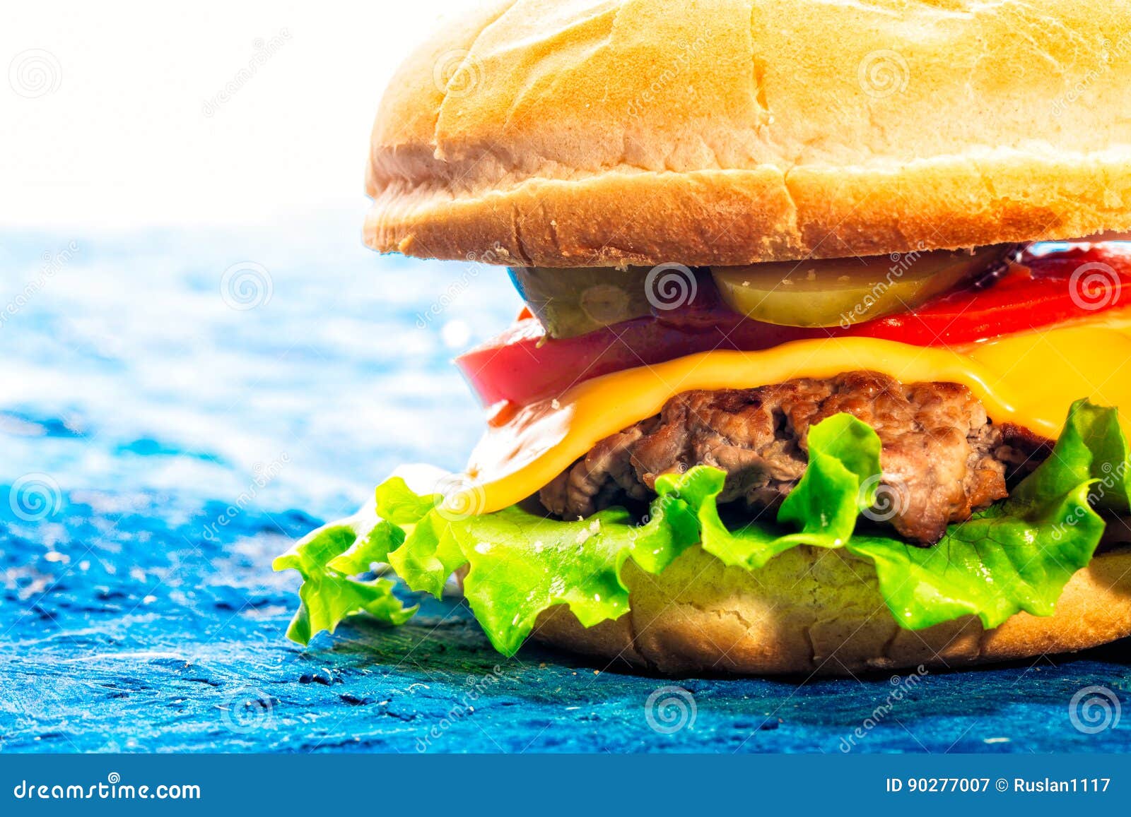 Cheeseburger Closeup on a Blue Background Stock Image - Image of ...