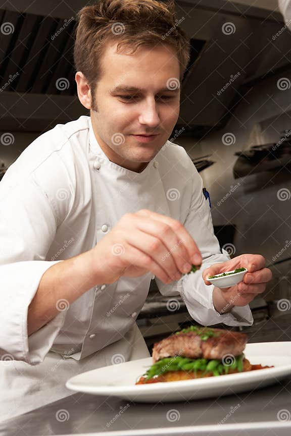 Chef Adding Seasoning To Dish in Restaurant Stock Photo - Image of ...