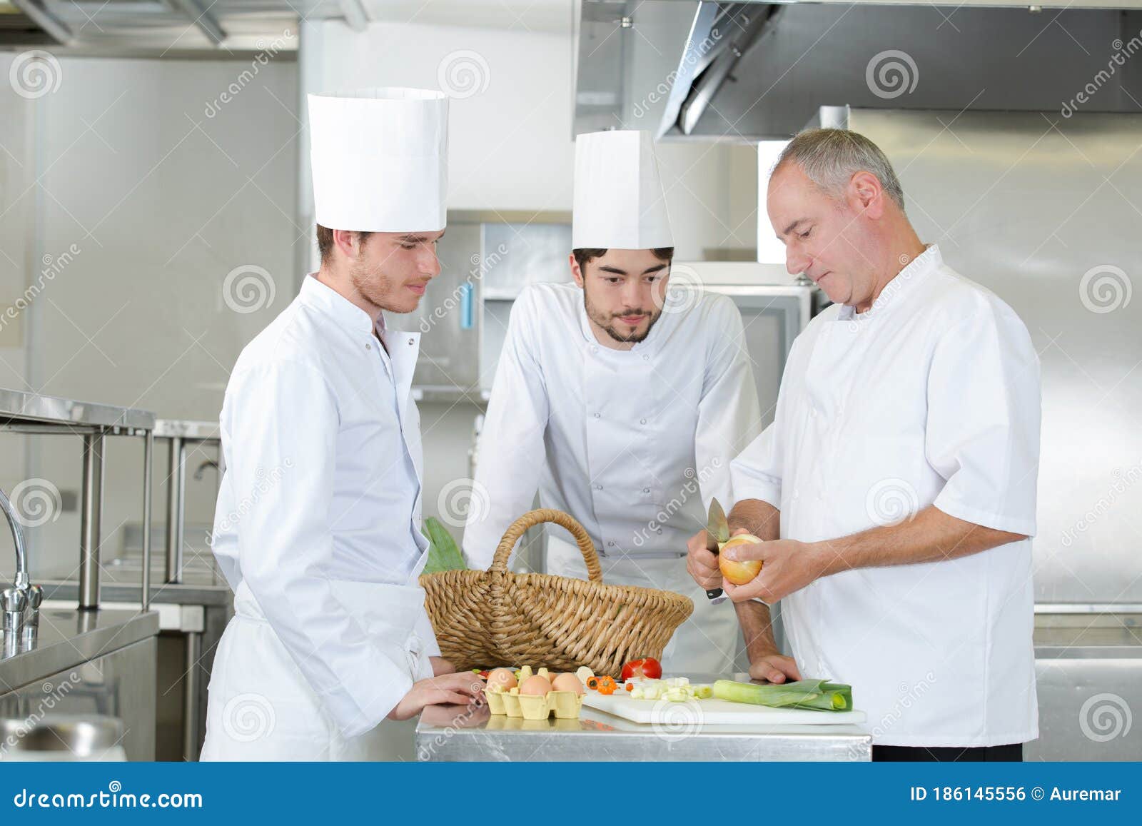 Chef and Apprentice Cooks Working at Restaurant Kitchen Together Stock ...