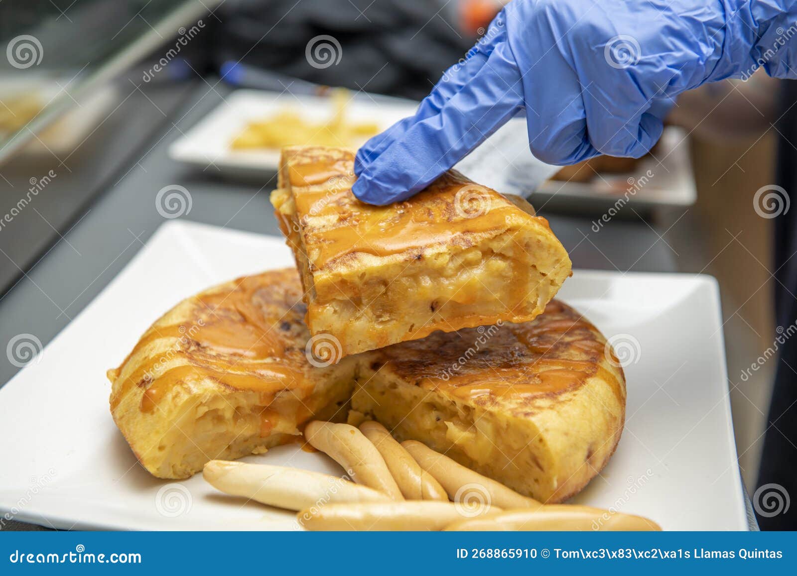 A Chef with Blue Plastic Gloved Hands Separating a Piece of Spanish ...