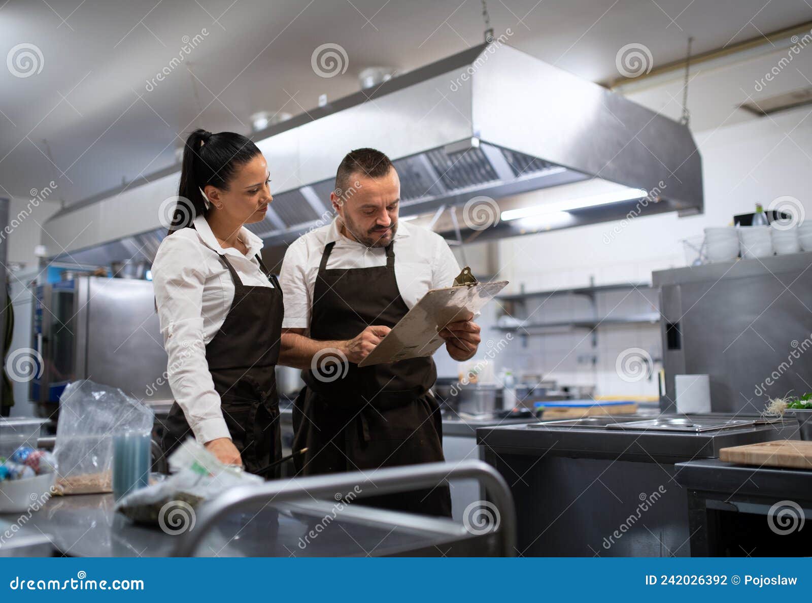 Chef and Cook Discussing Menu Indoors in Restaurant Kitchen. Stock ...