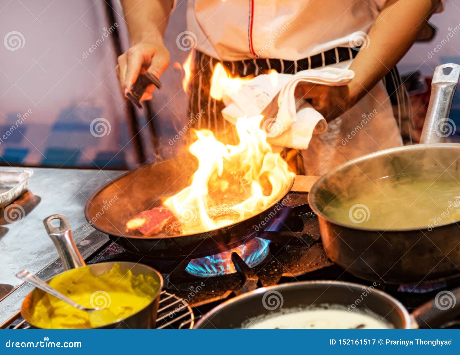 Chef Cooking with Flame in a Frying Pan on a Kitchen Stove Stock Image ...