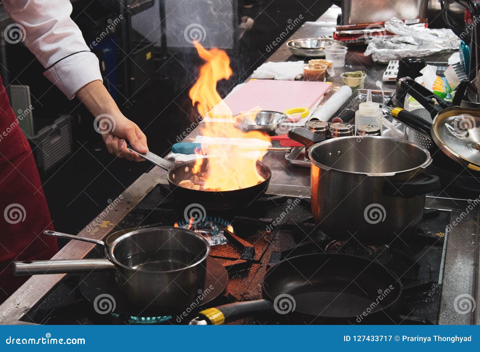 Chef Cooking with Flame in a Frying Pan on a Kitchen Stove Stock Image ...
