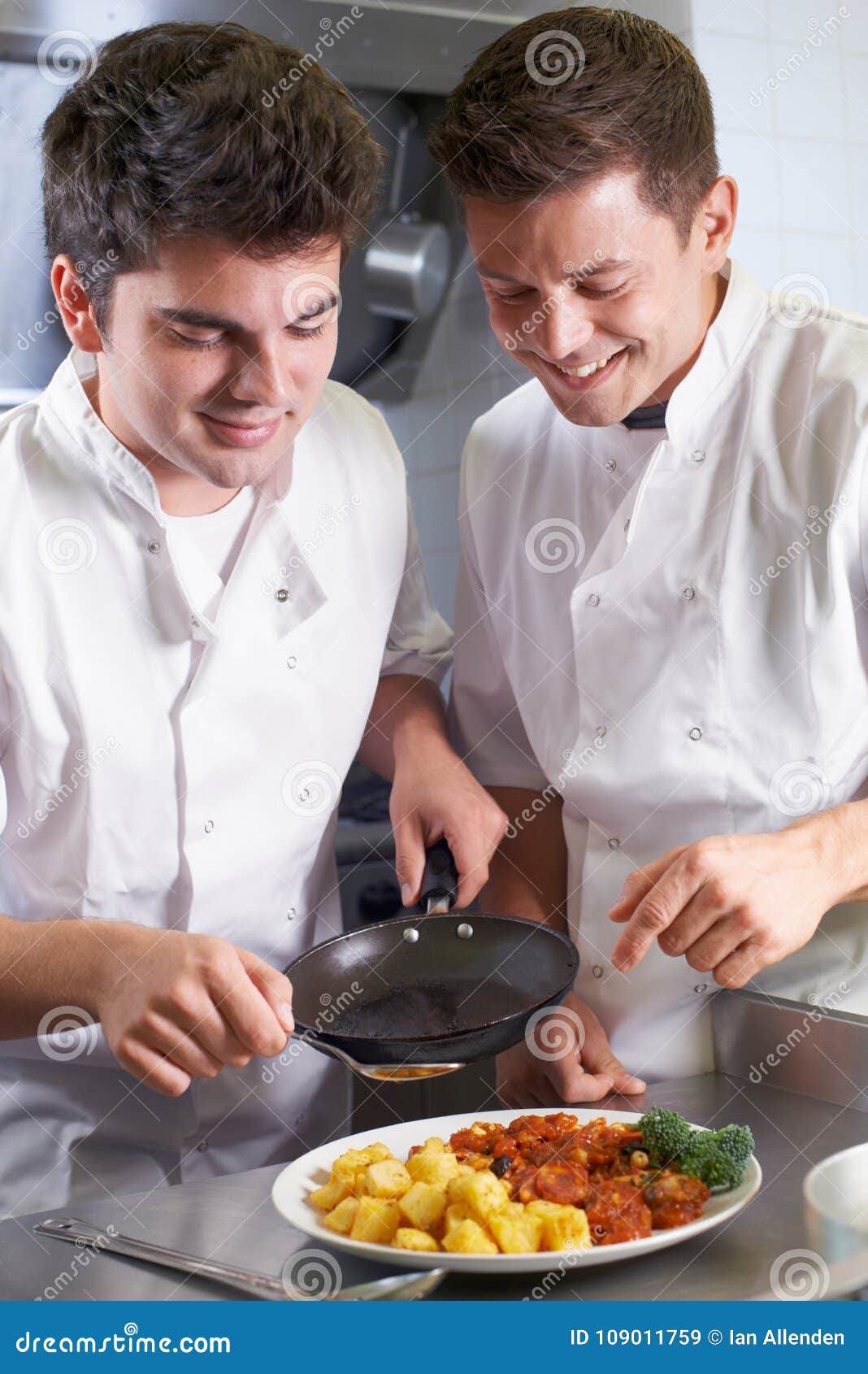Chef Instructing Male Trainee in Restaurant Kitchen Stock Image - Image ...