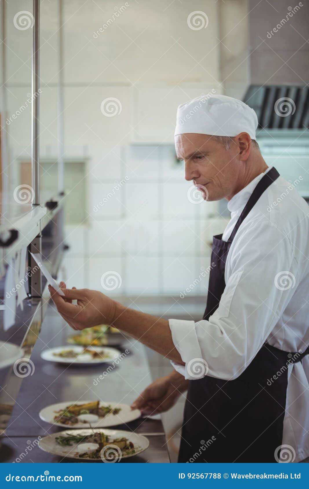 Chef Looking at an Order List in the Commercial Kitchen Stock Photo ...