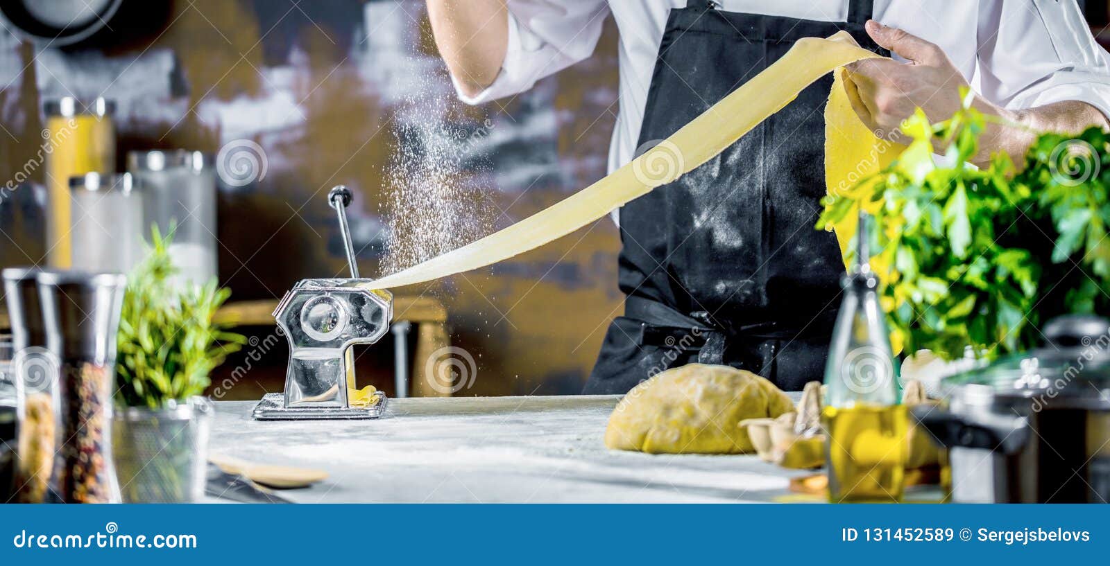 Chef Making Spaghetti Noodles with Pasta Machine on Kitchen Table with ...