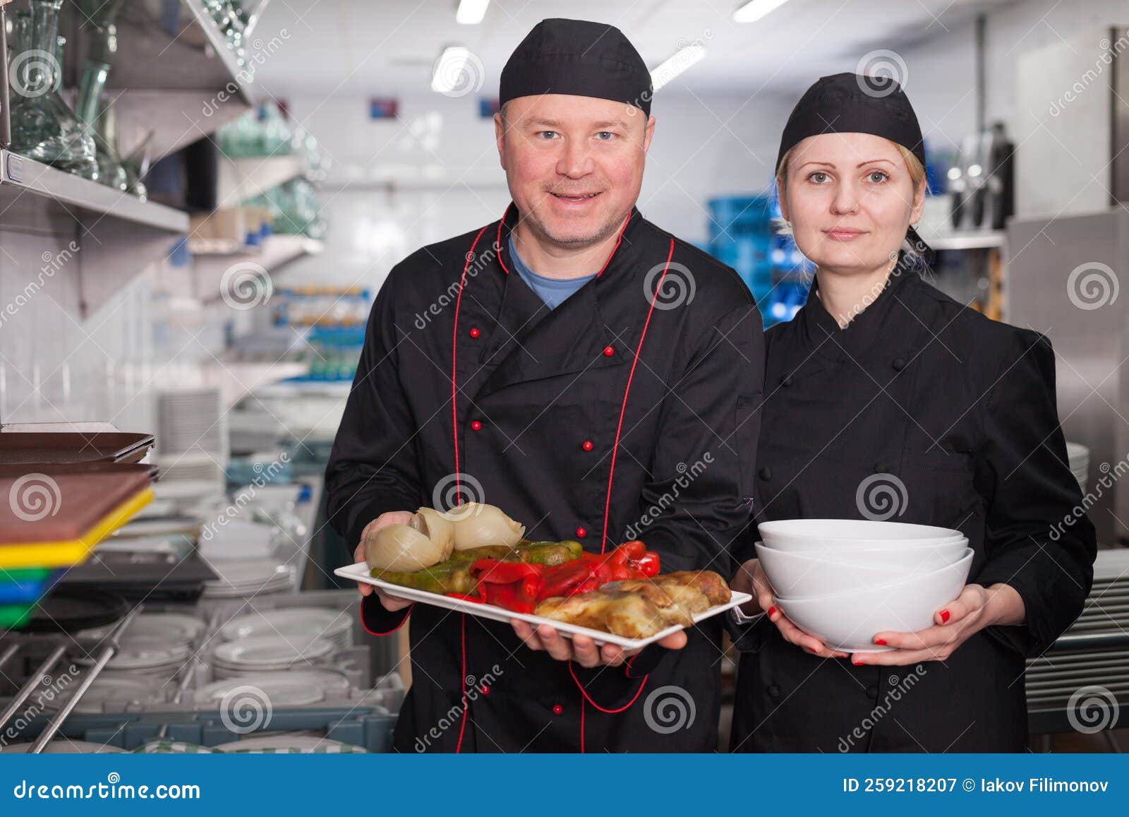 Chef Masculino Con Asistente Femenina Que Presenta Plato Cocinado ... Chef Masculino Con Asistente Femenina Que Presenta Plato Cocinado ...