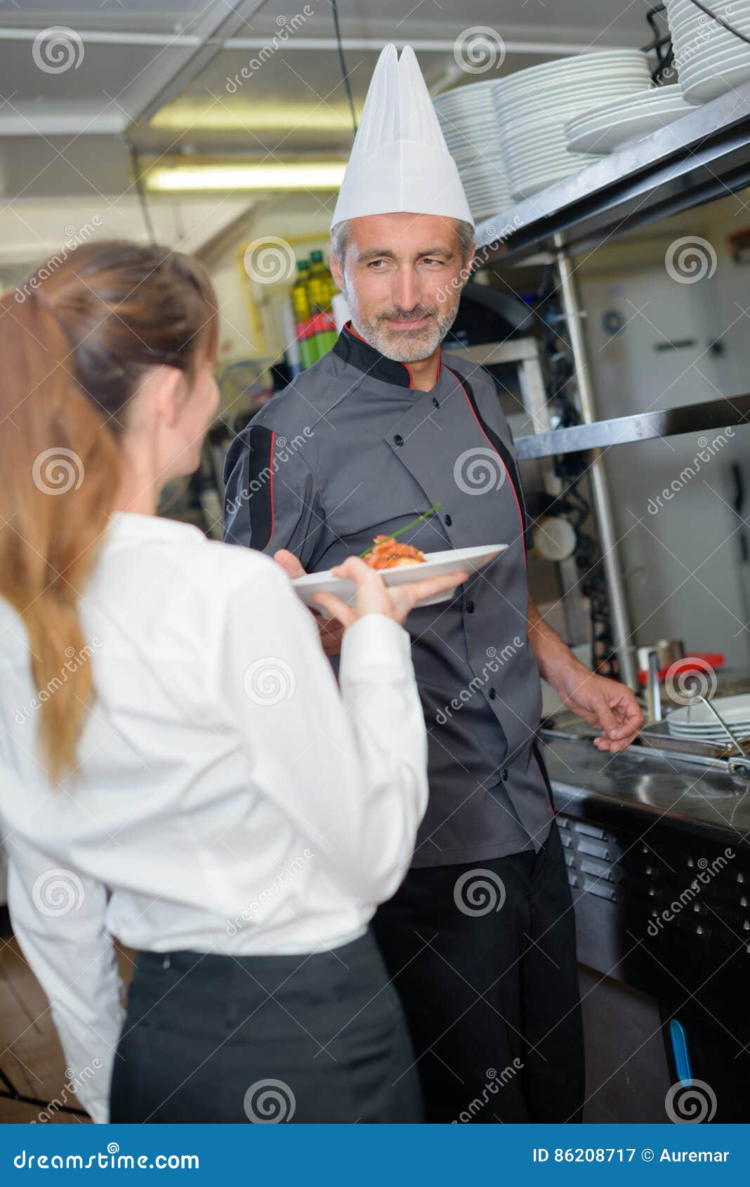 Chef Passes Plate Food To Waitress in Kitchen Stock Image - Image of ...