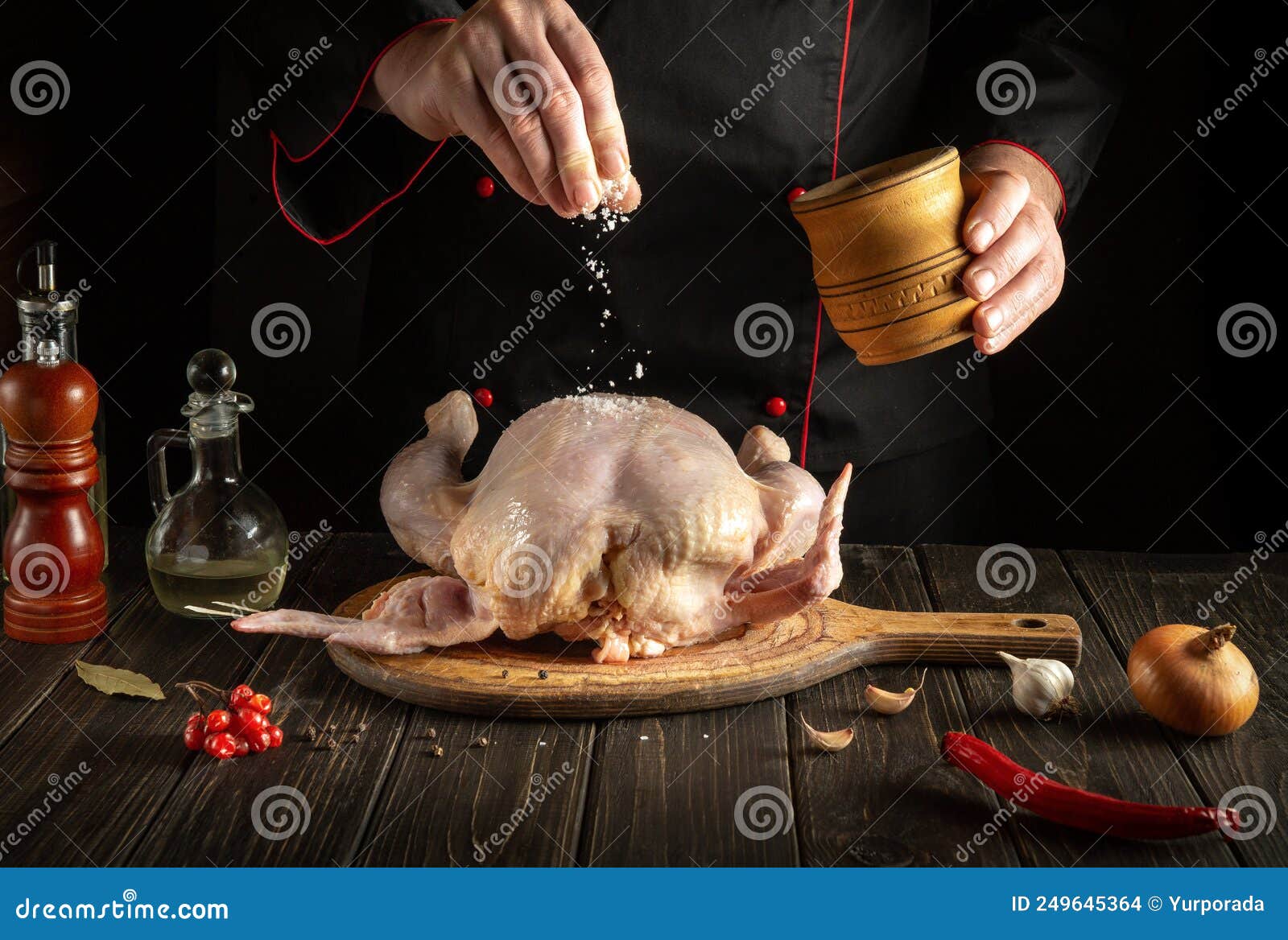 The Chef Preparing Raw Chicken in the Kitchen. the Cook Adds Salt To ...