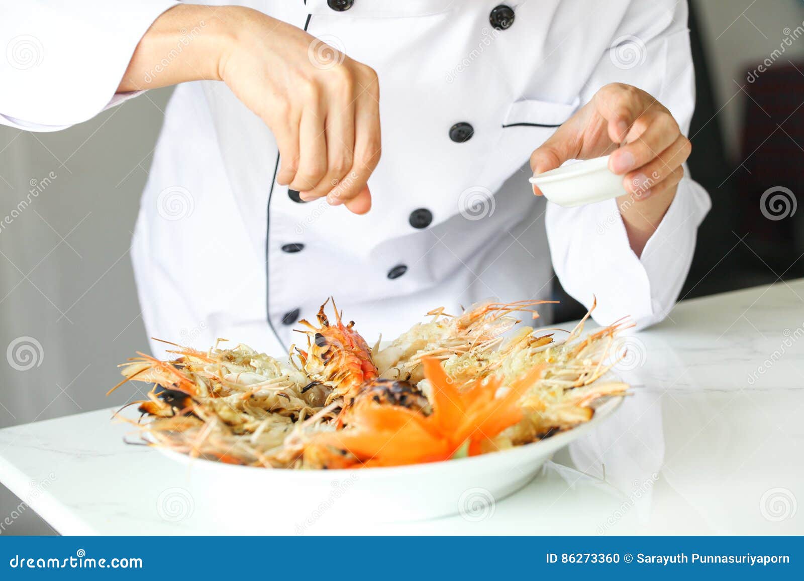 Chef Sprinkling Salt All Over Grilled Prawns in the Kitchen. Stock ...