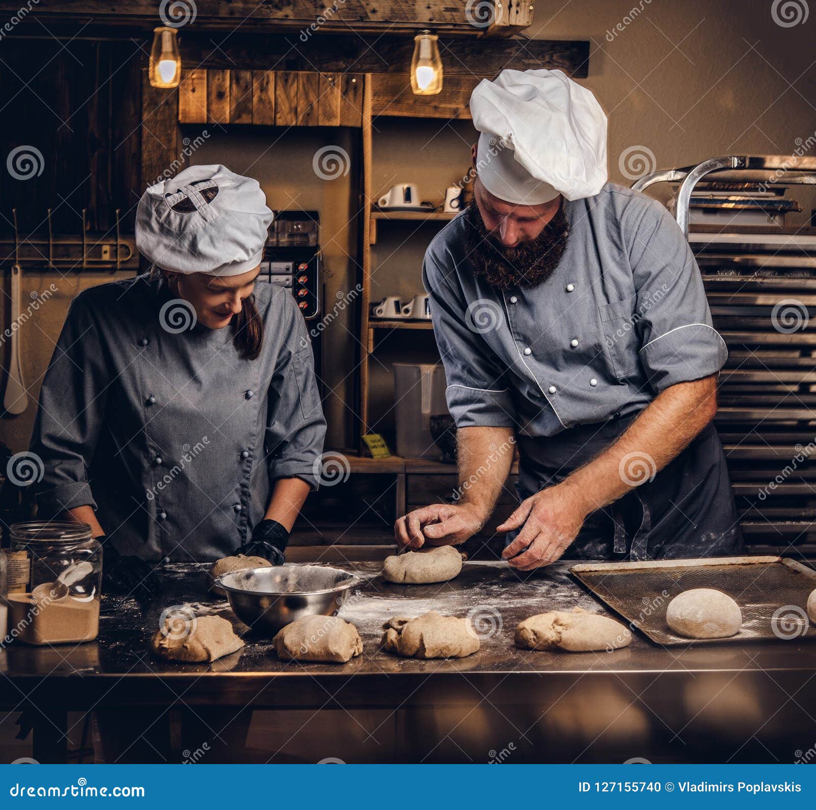 Chef Teaching His Assistant To Bake the Bread in a Bakery. Stock Photo ...