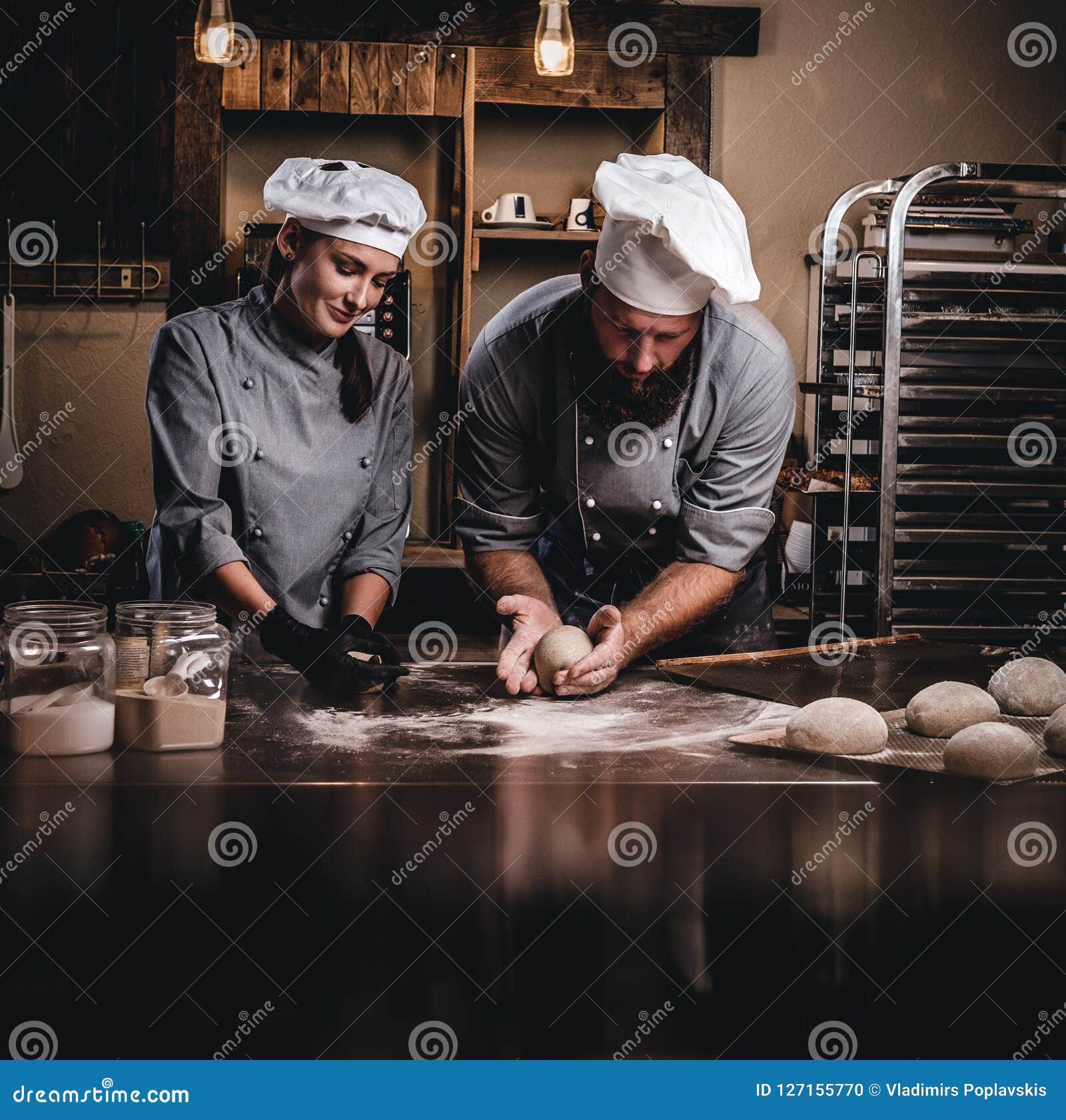 Chef Teaching His Assistant To Bake the Bread in a Bakery. Stock Photo ...