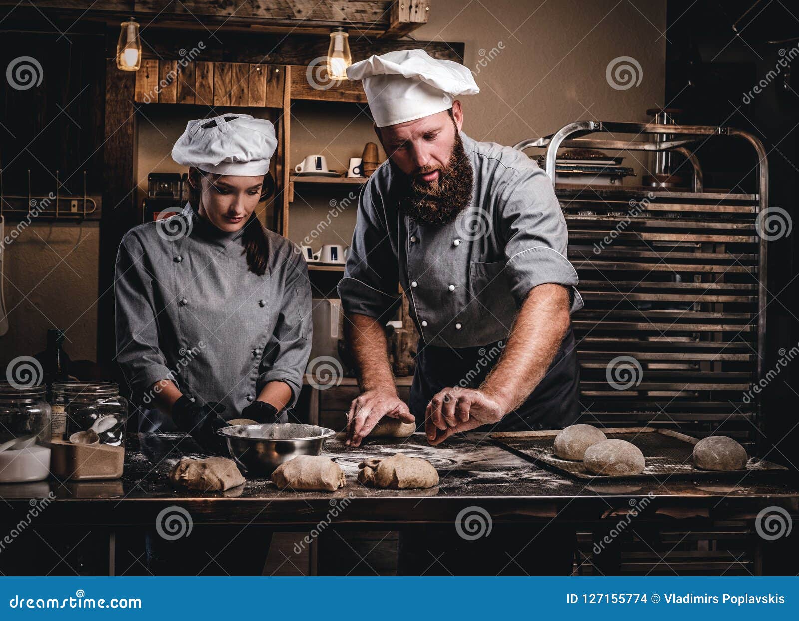 Chef Teaching His Assistant To Bake the Bread in a Bakery. Stock Photo ...