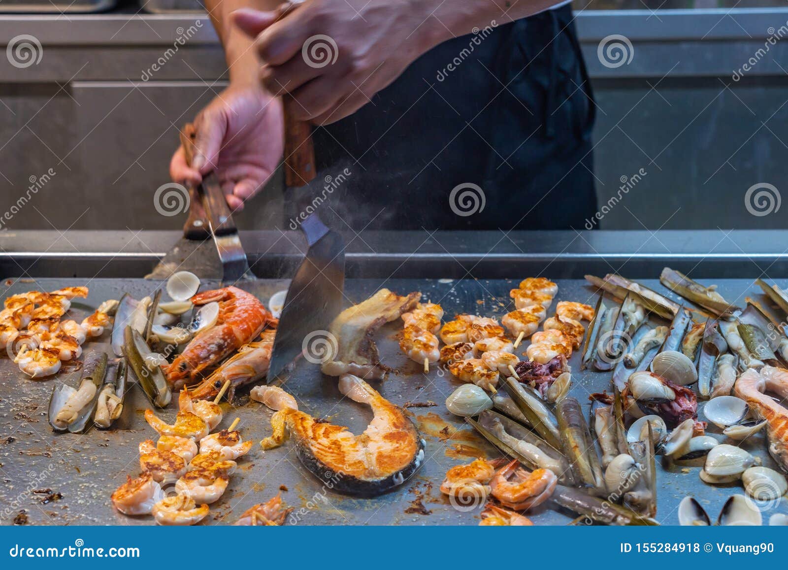 Chef Using Spatula Frying Assortment of Seafood in Restaurant`s Kitchen ...