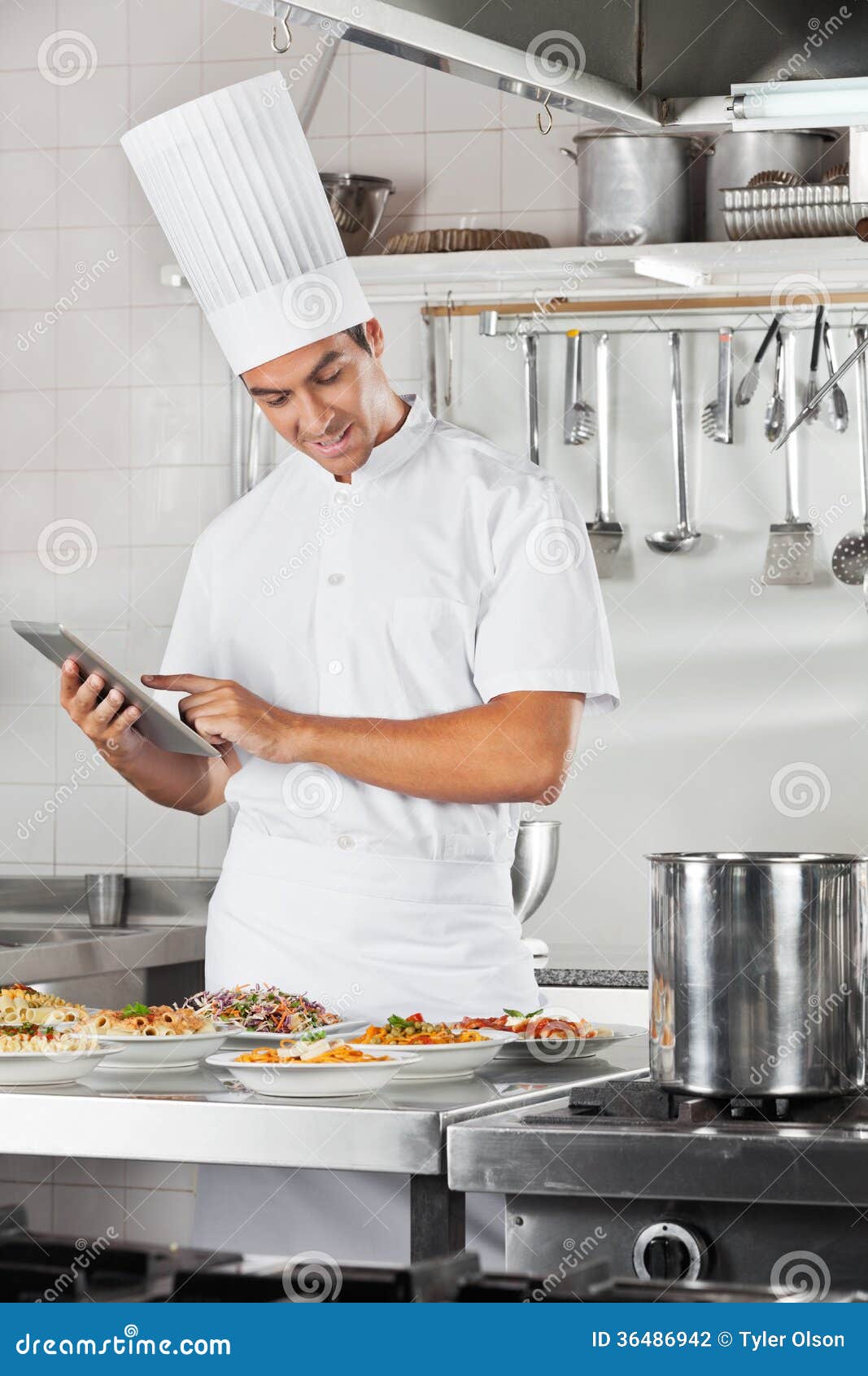 Chef Using Tablet with Pasta Dishes at Counter Stock Photo - Image of ...