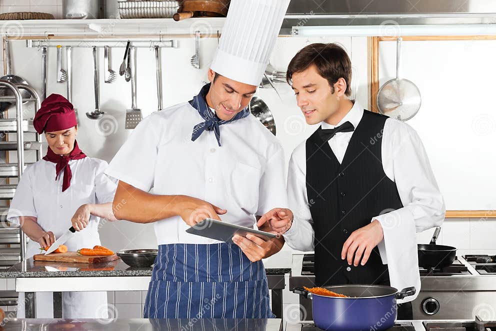 Waiter and Chef Using Digital Tablet in Kitchen Stock Photo - Image of ...