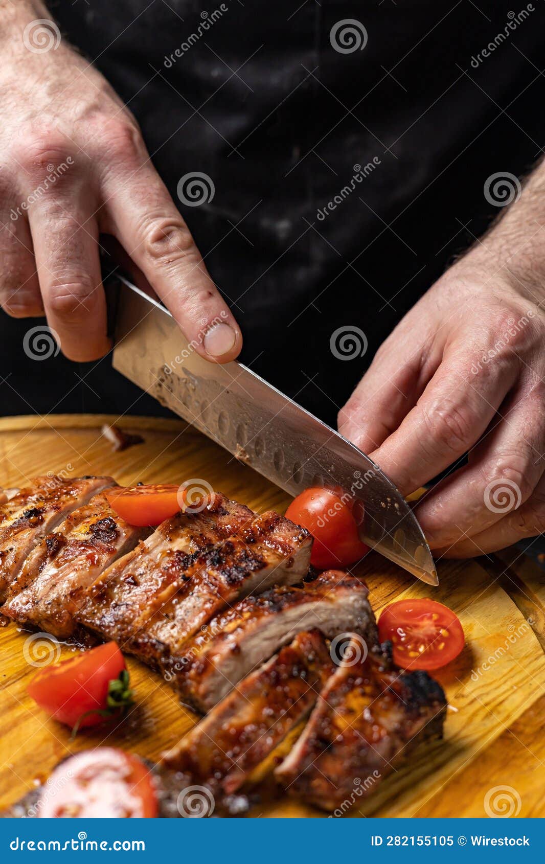 Chef Wearing a Black Apron Using a Sharp Kitchen Knife To Cut a Section ...
