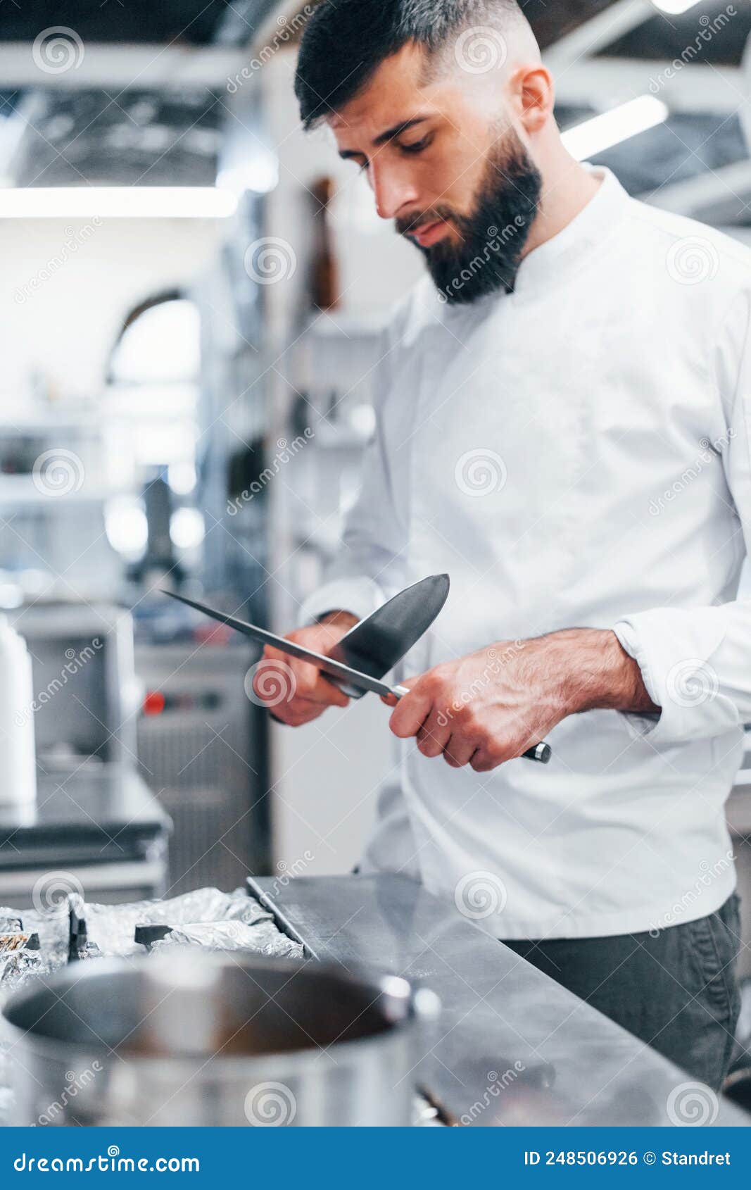 Chef in White Uniform Standing at Kitchen. Holding Knives in Hands ...