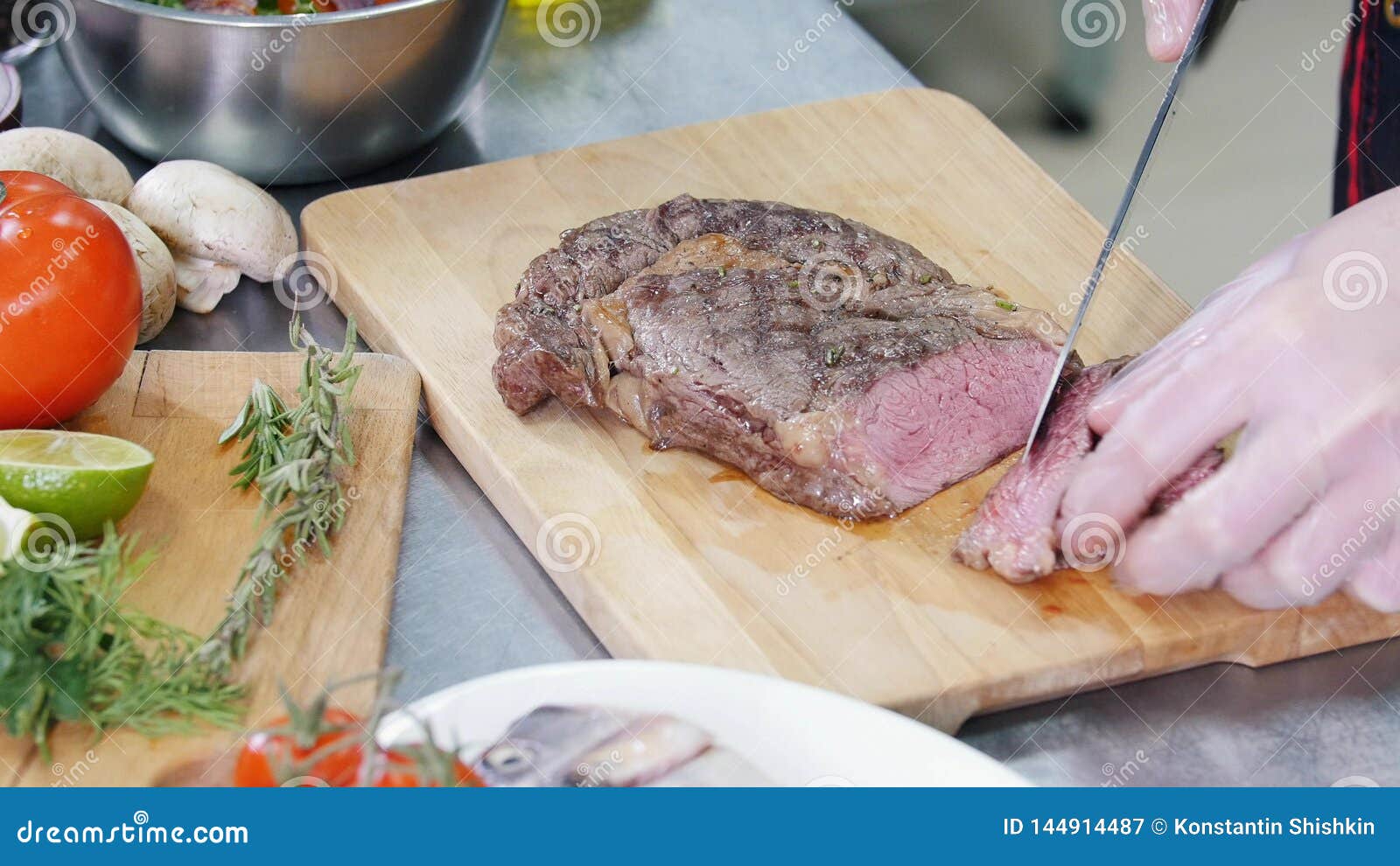 A Chef Working in the Kitchen. a Man Cutting the Steak on Pieces Stock ...