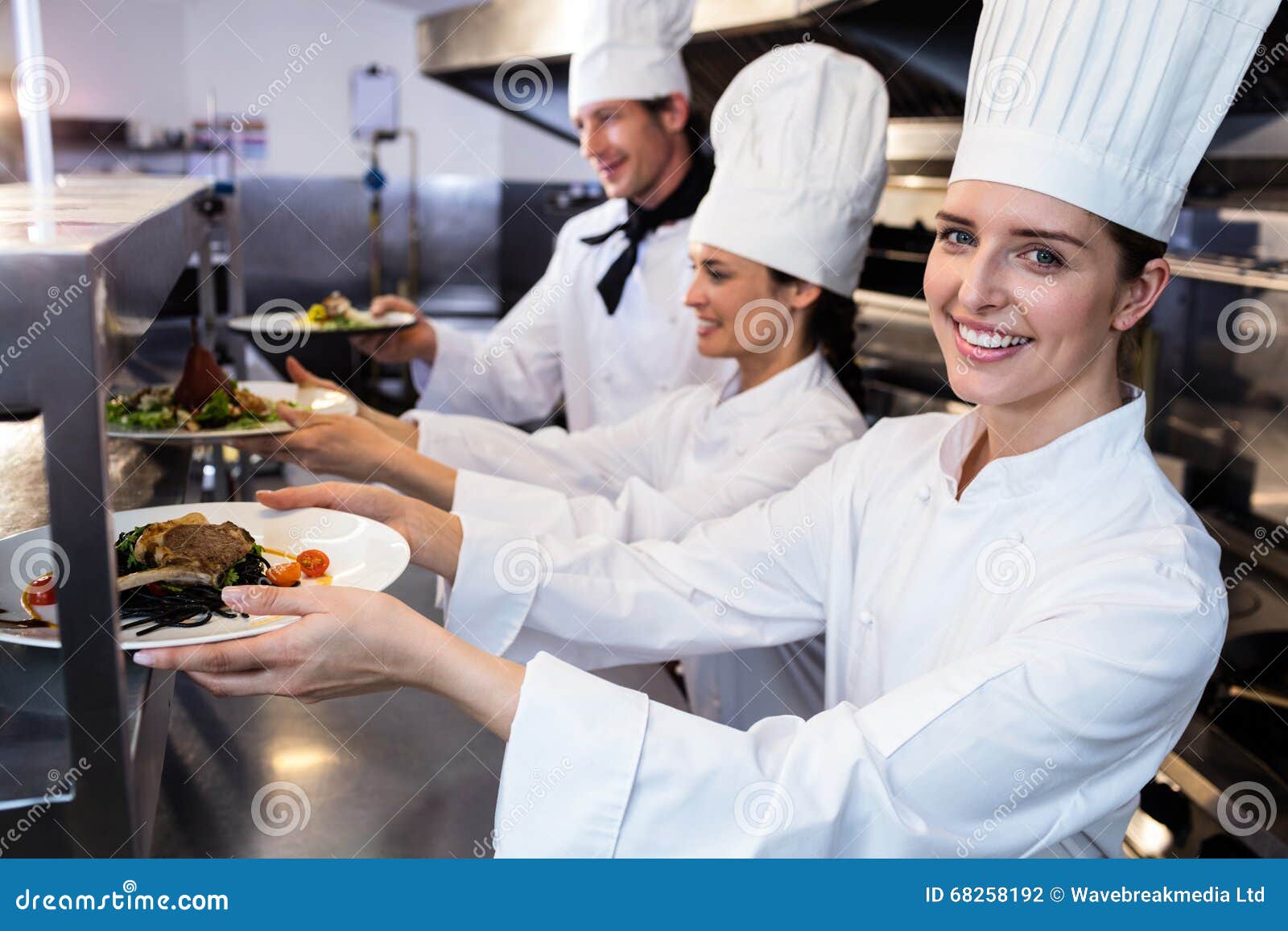 Chefs Handing Dinner Plates through Order Station Stock Photo - Image ...