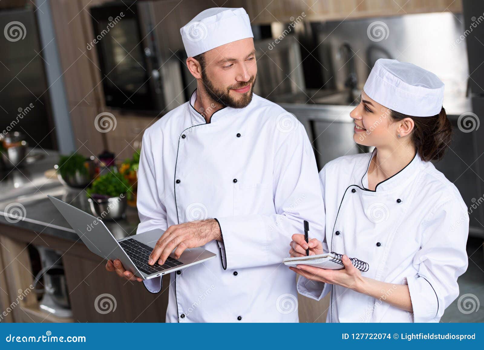 Chefs Using Laptop at Restaurant Kitchen and Looking Stock Photo ...