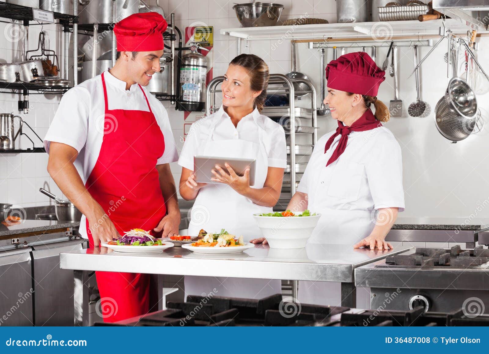 Chefs Using Tablet Computer at Kitchen Counter Stock Photo - Image of ...