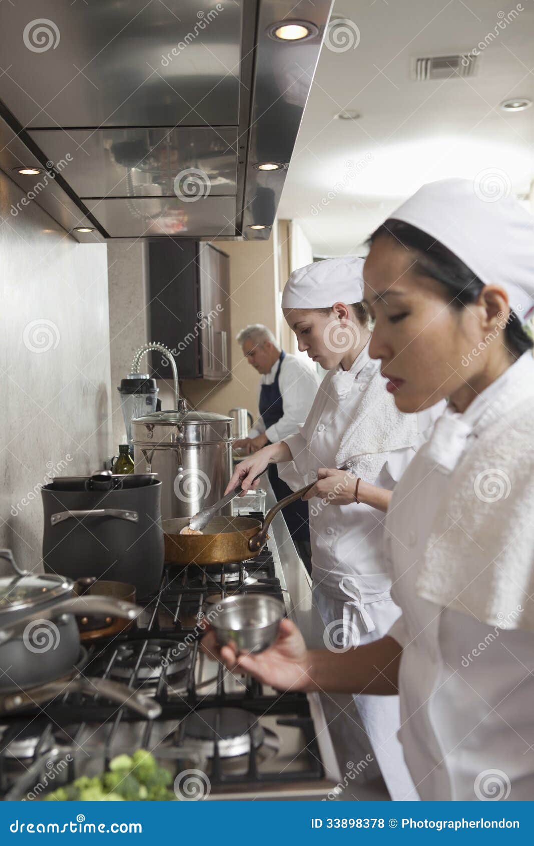 Chefs Working Together in Commercial Kitchen Stock Photo - Image of ...