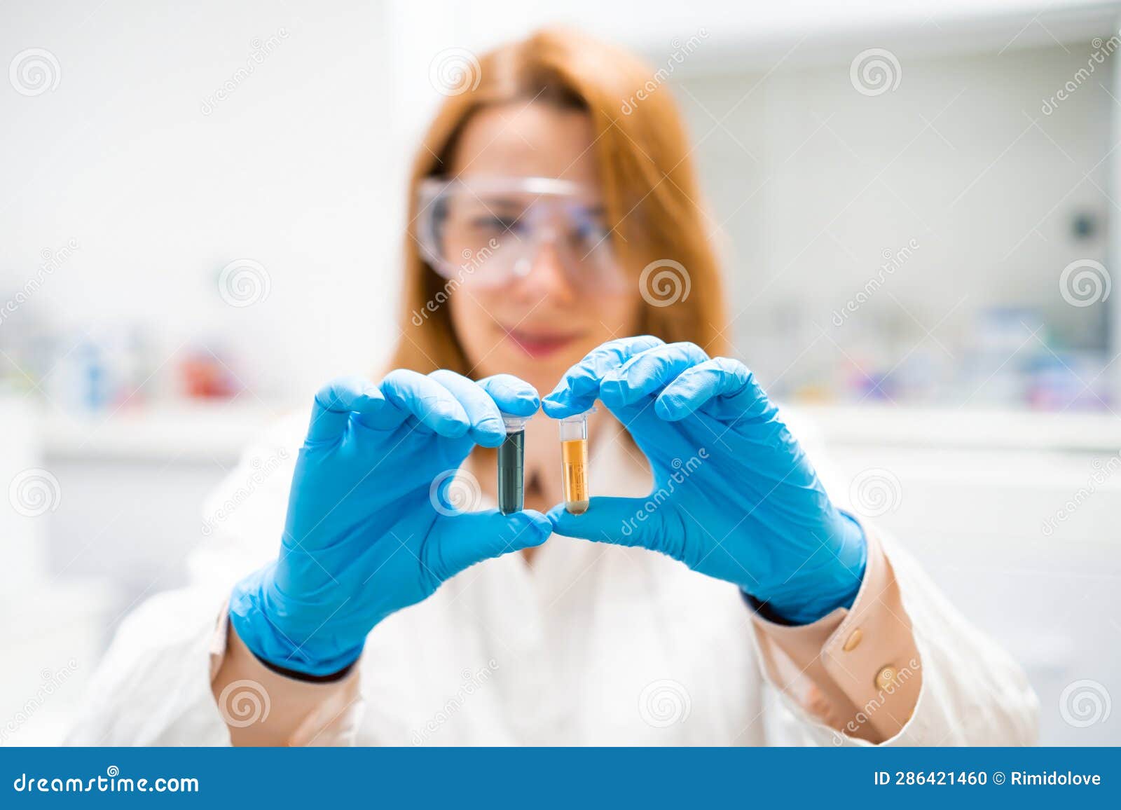 Chemist in Goggles Shaking Test Tubes with Blue and Yellow Solution ...